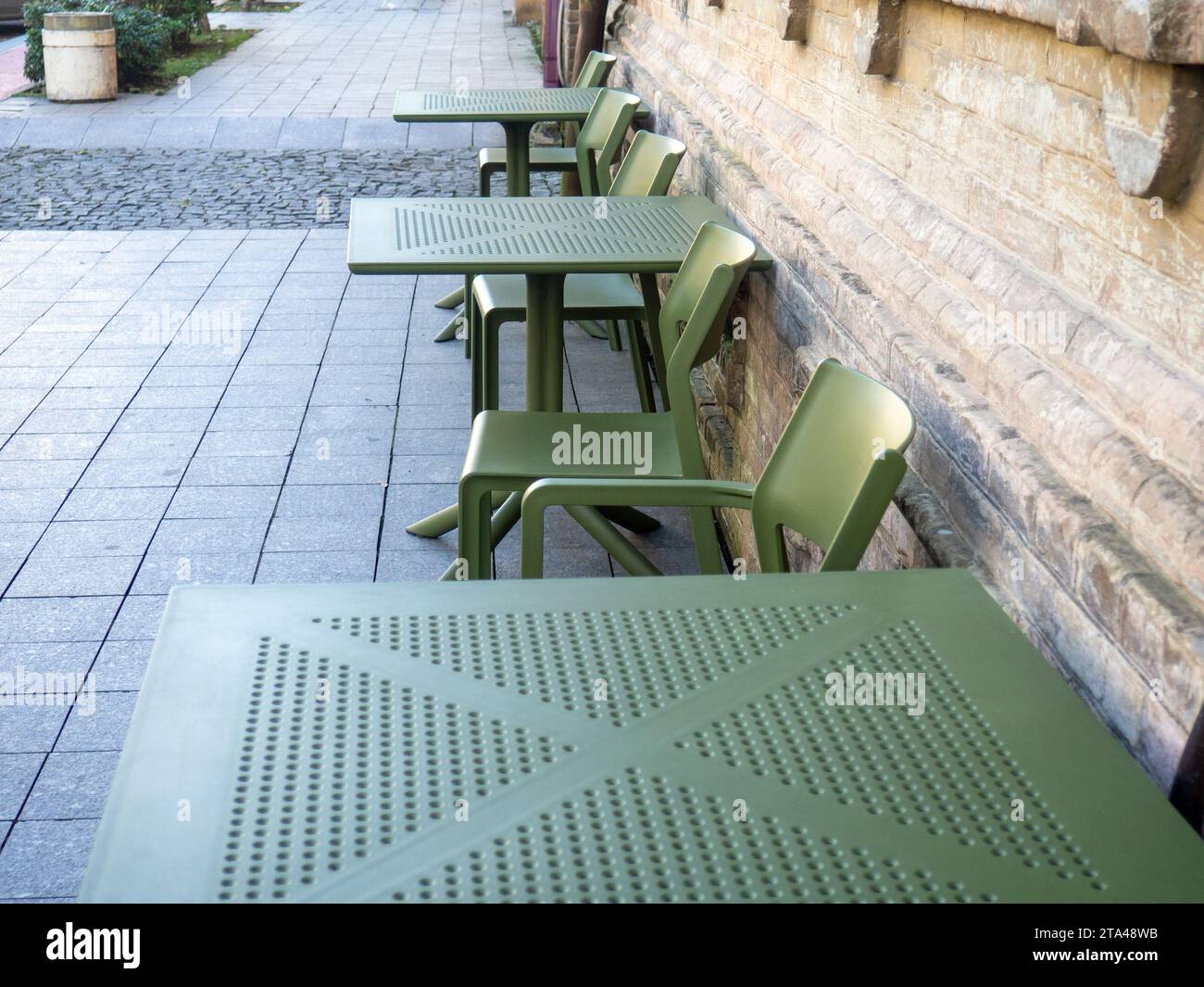 Empty plastic tables in a cafe. Green chairs and tables outside. The ...