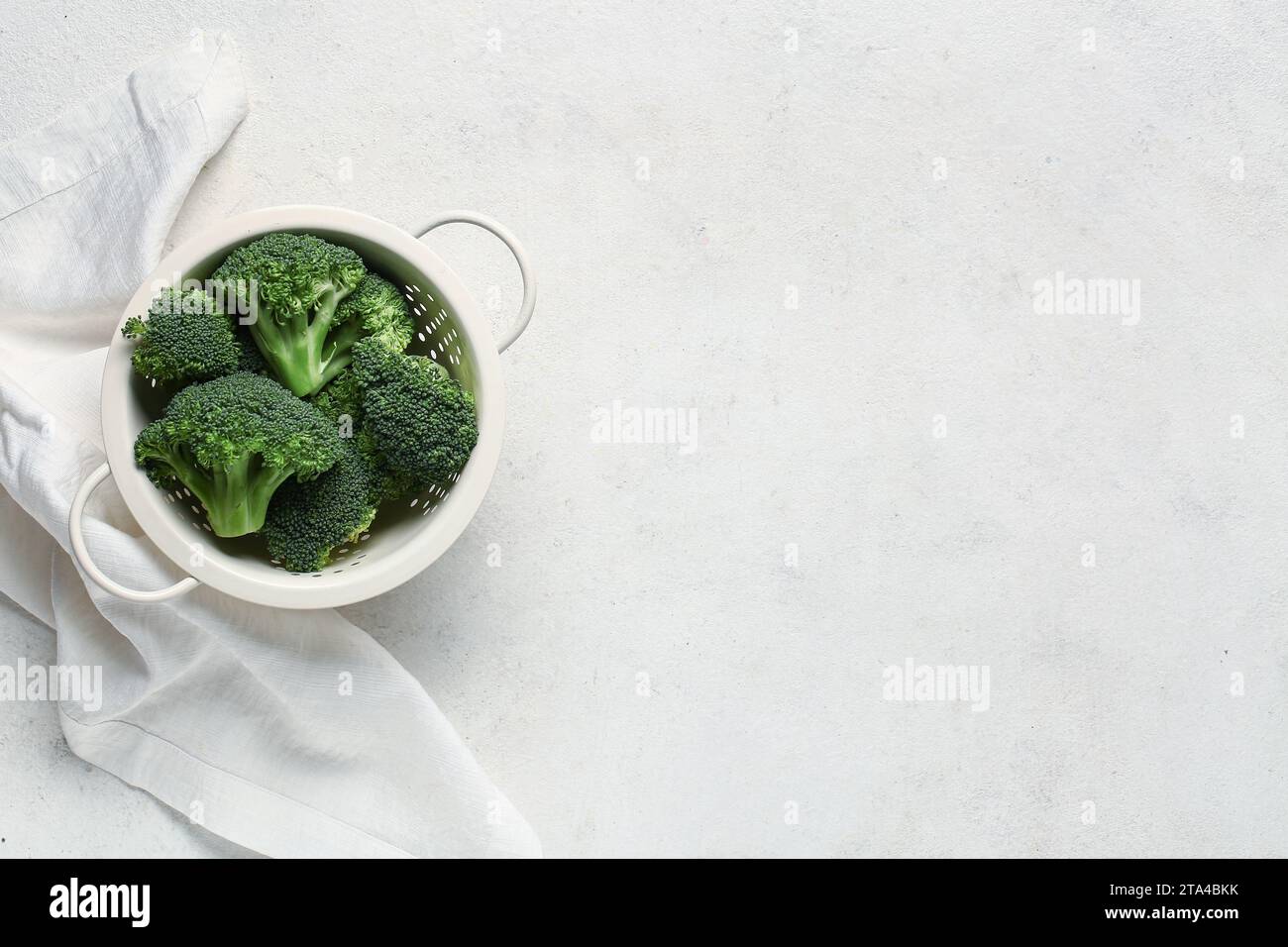 Colander with fresh broccoli cabbages on white background Stock Photo ...