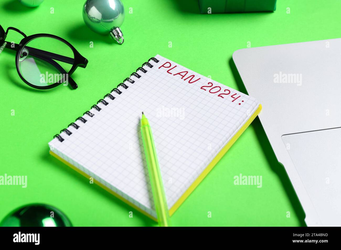 Notebook with text PLAN 2024, pen and eyeglasses on green background ...