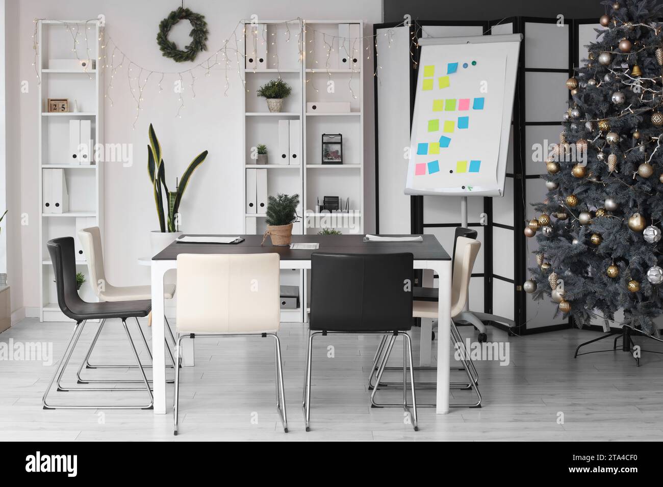 Interior of office with table and Christmas tree Stock Photo - Alamy