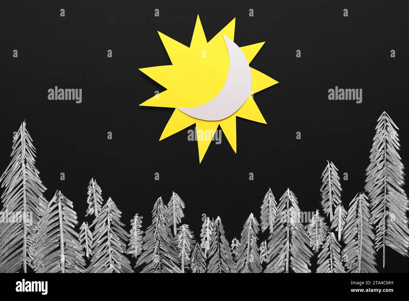 Paper sun with crescent and drawn fir trees on dark background. Winter ...