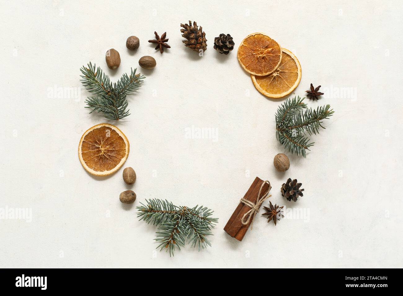 Frame made of fir branches with dried oranges and nuts on white ...