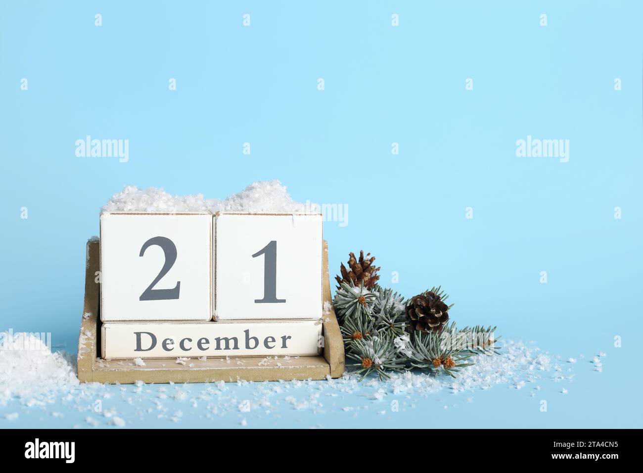 Cube calendar with date of winter solstice, fir branches and snow on ...