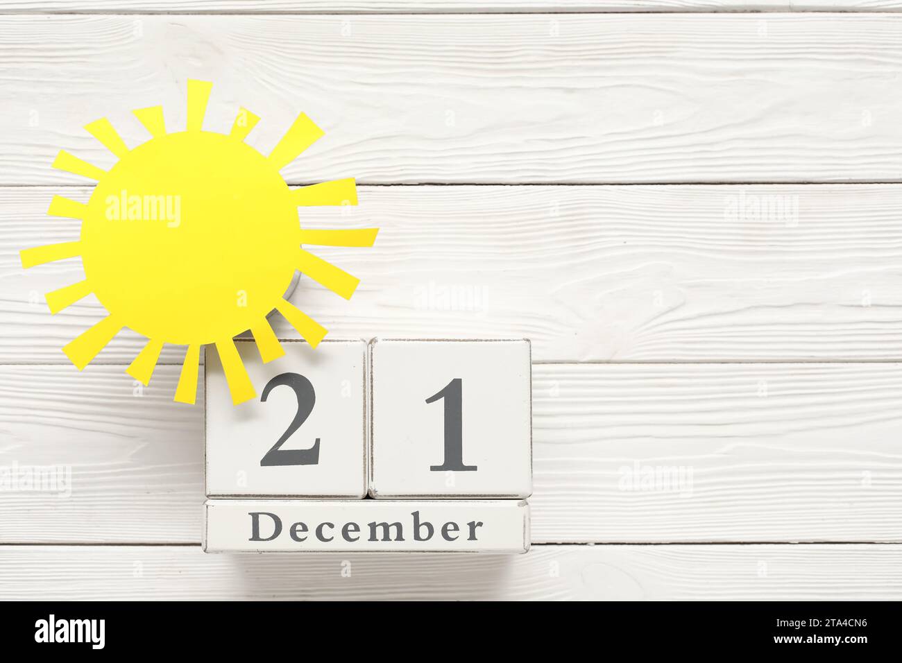 Cube calendar with date of winter solstice and paper sun on white ...