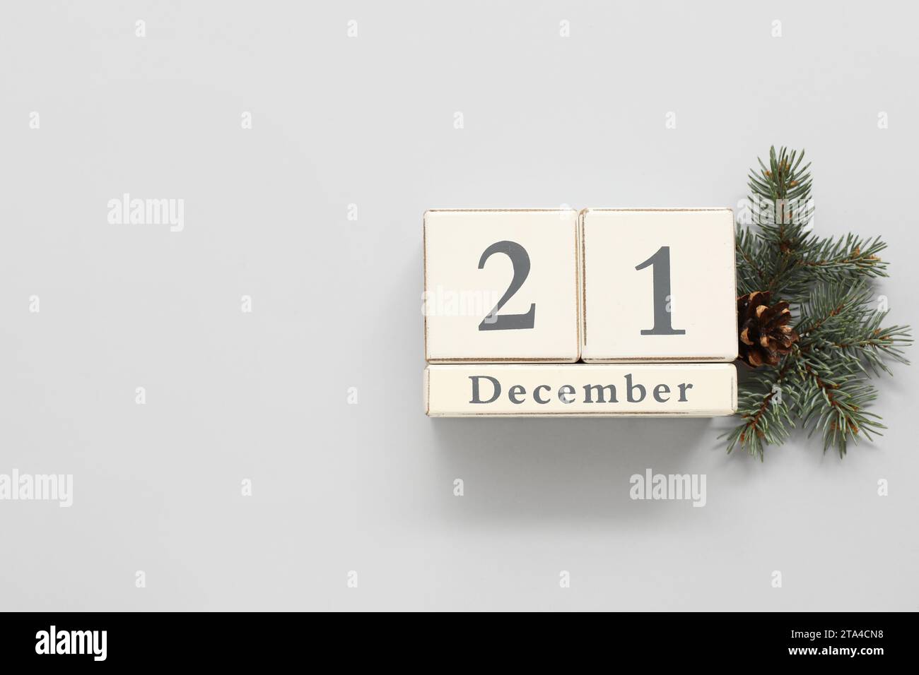 Cube calendar with date of winter solstice and fir branches on light ...