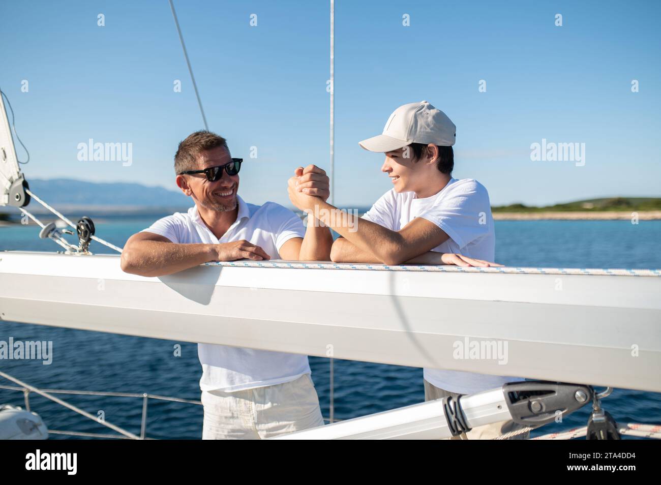 Father and son sailing and looking happy and joyful Stock Photo - Alamy