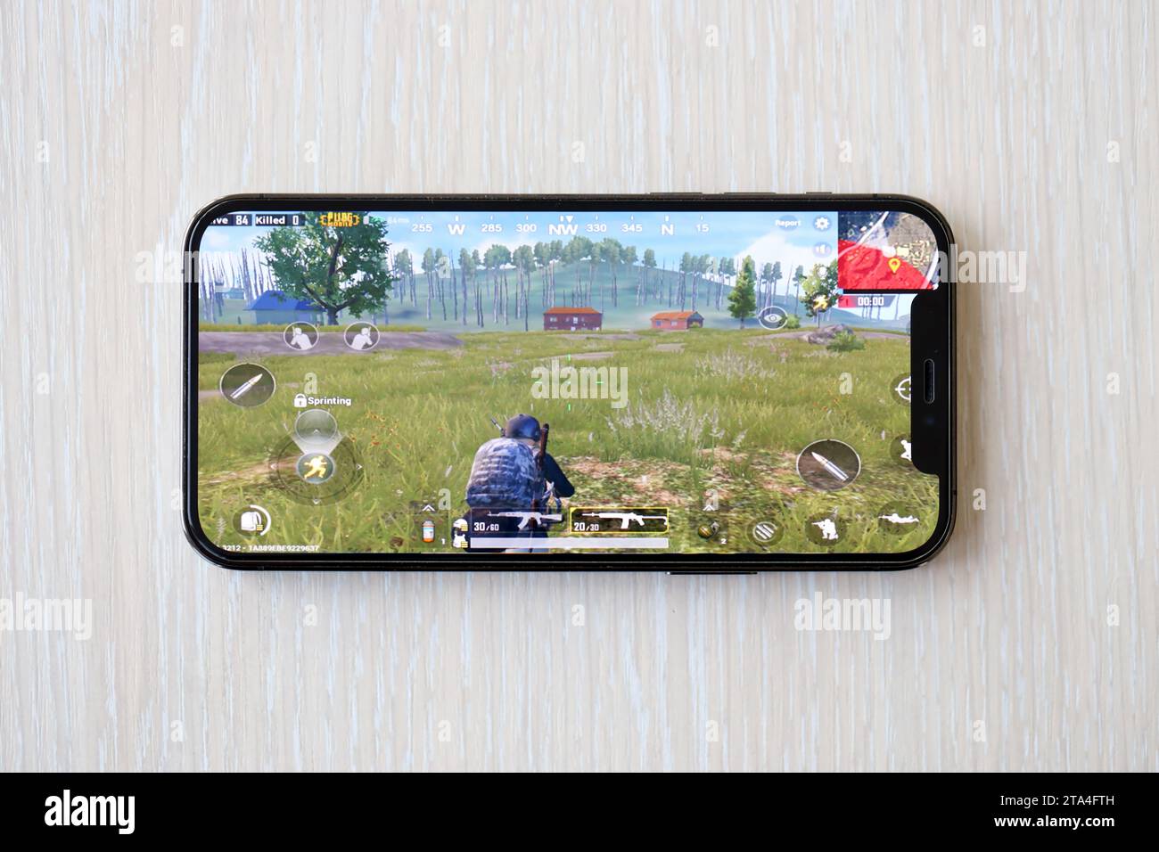 PUBG PlayerUnknowns Battlegrounds mobile iOS game on iPhone 15 smartphone screen on wooden table ...