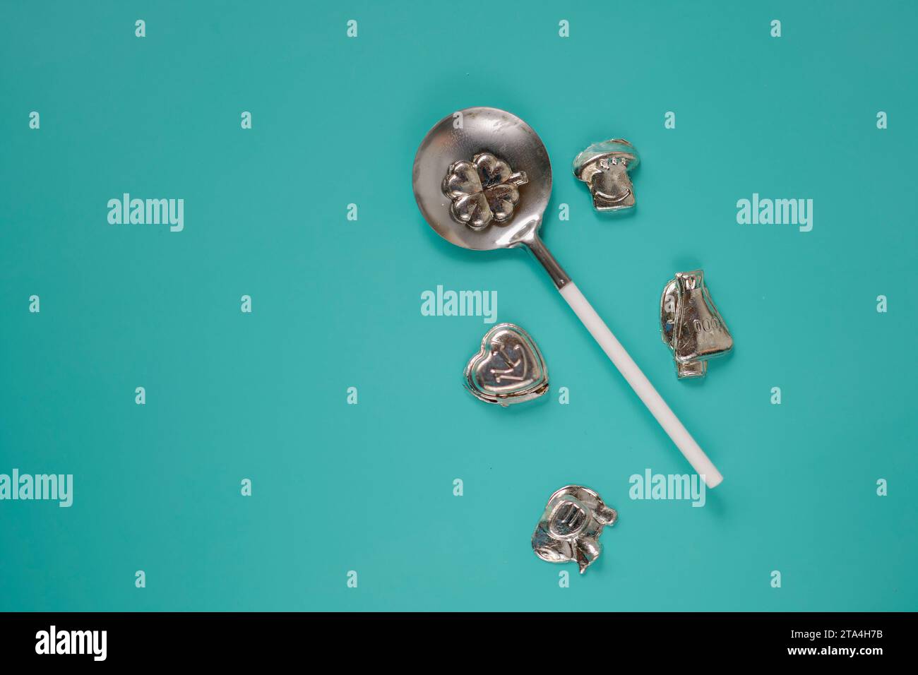 lead pouring set for New Years party.Tin spoon and tin figurines on a ...