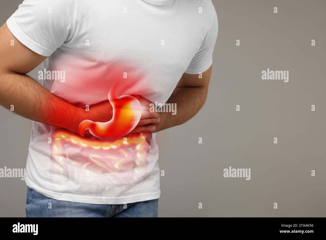 Man suffering from stomach ache on grey background, closeup and space ...