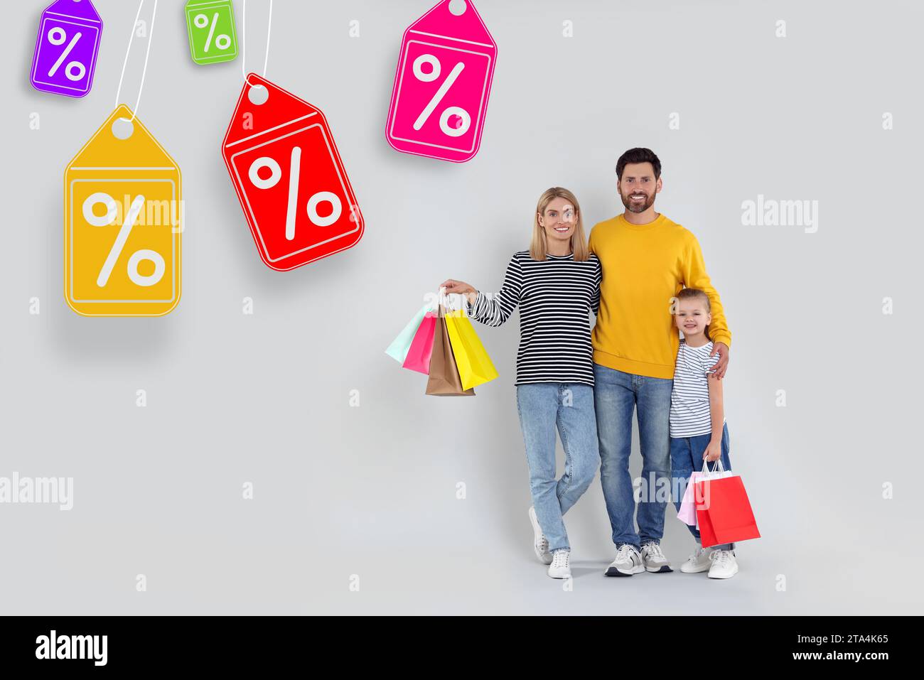 Discount offer. Happy family with paper shopping bags on light grey ...