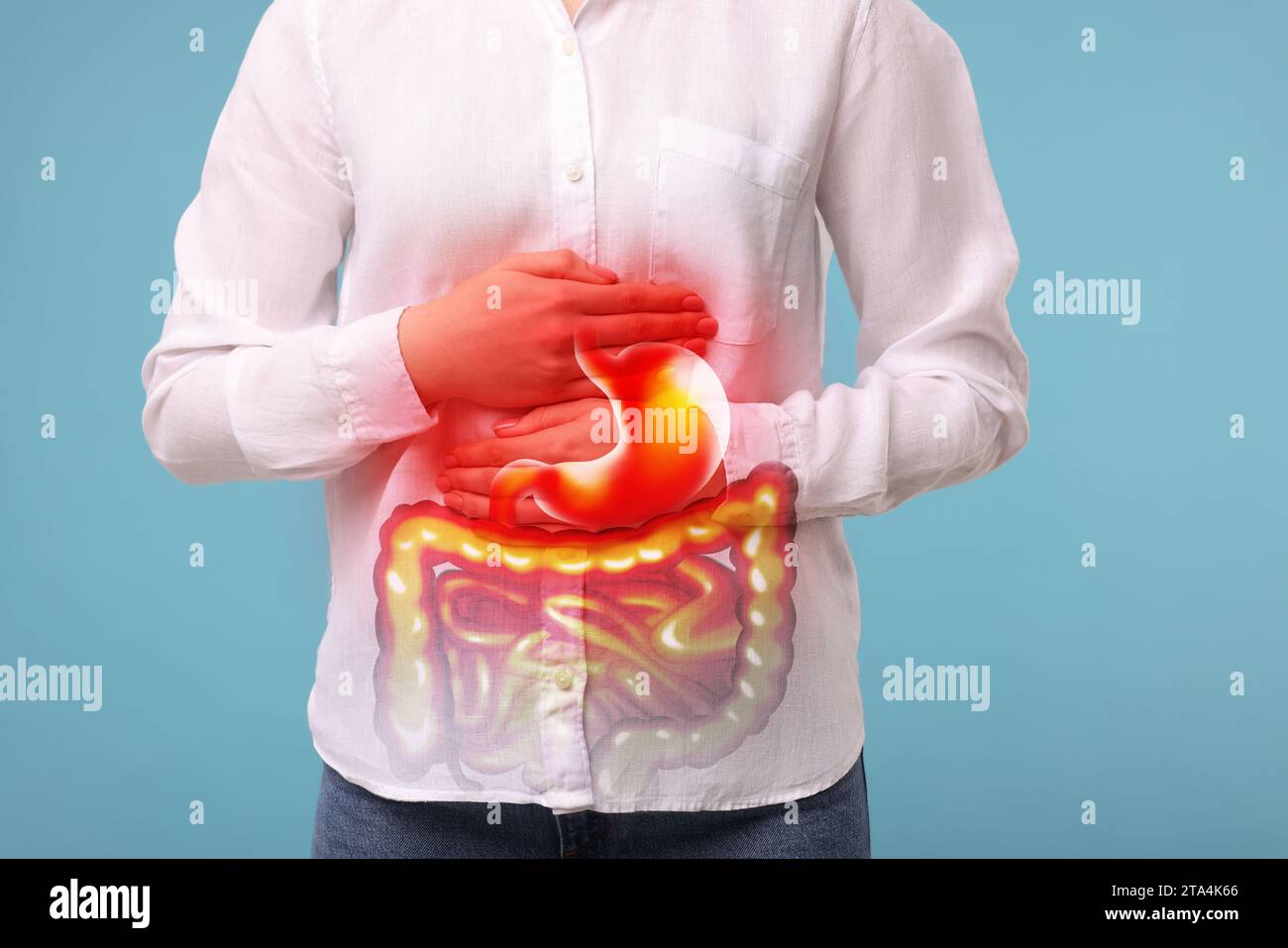 Woman suffering from stomach ache on light blue background, closeup ...
