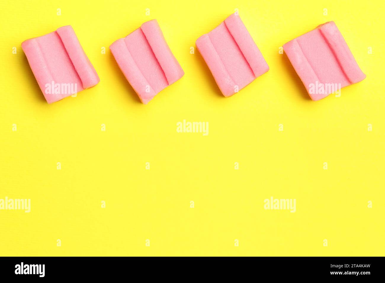 Pink bubble gums on yellow background, flat lay. Space for text Stock ...