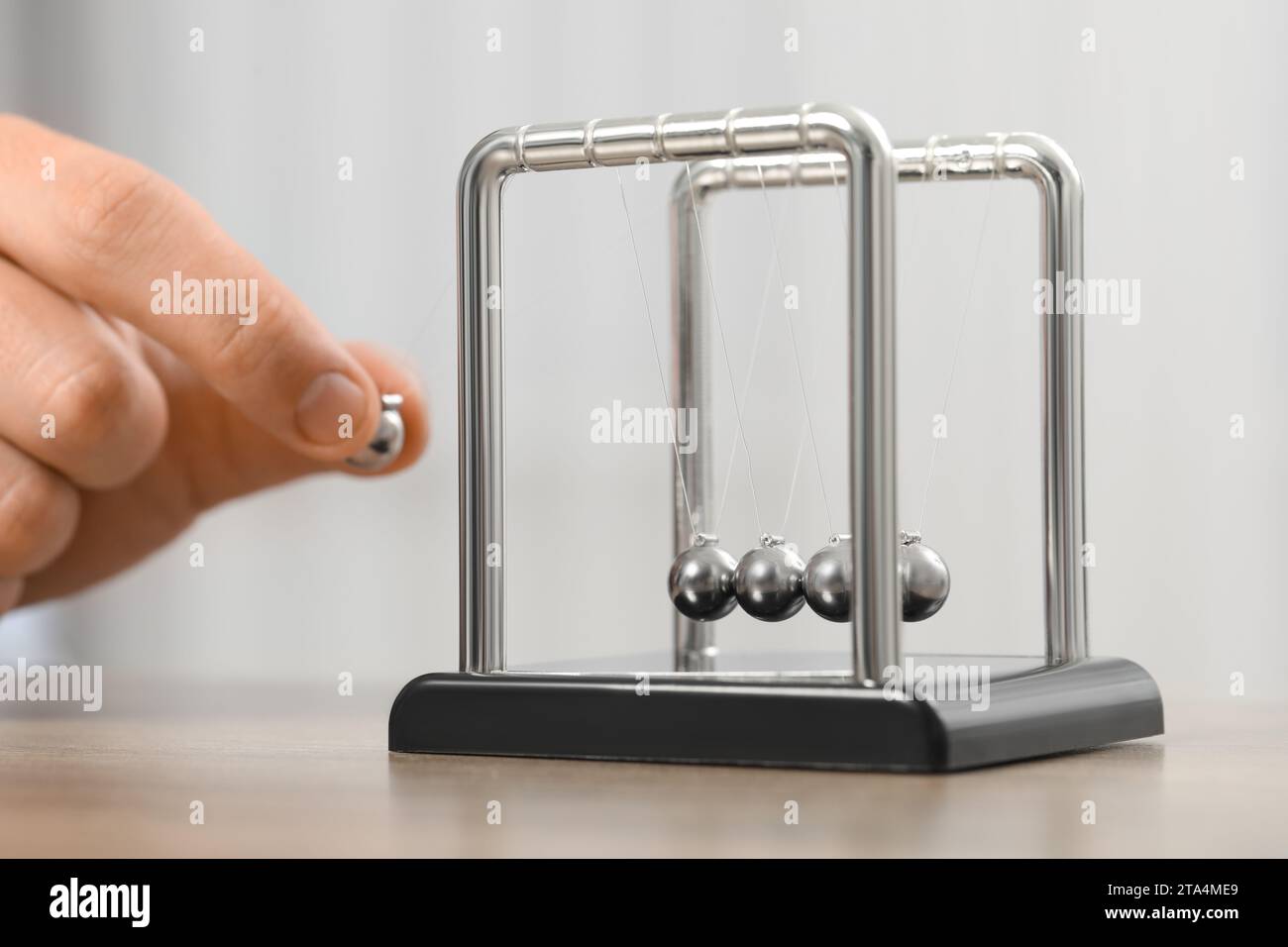 Newton's cradle and hand hi-res stock photography and images - Alamy