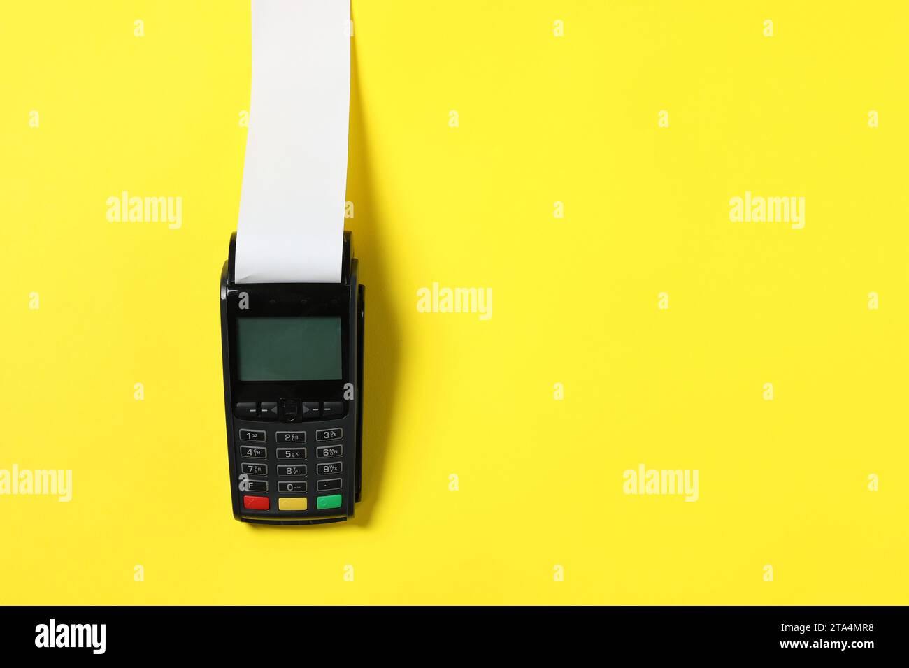 Payment terminal with thermal paper for receipt on yellow background ...
