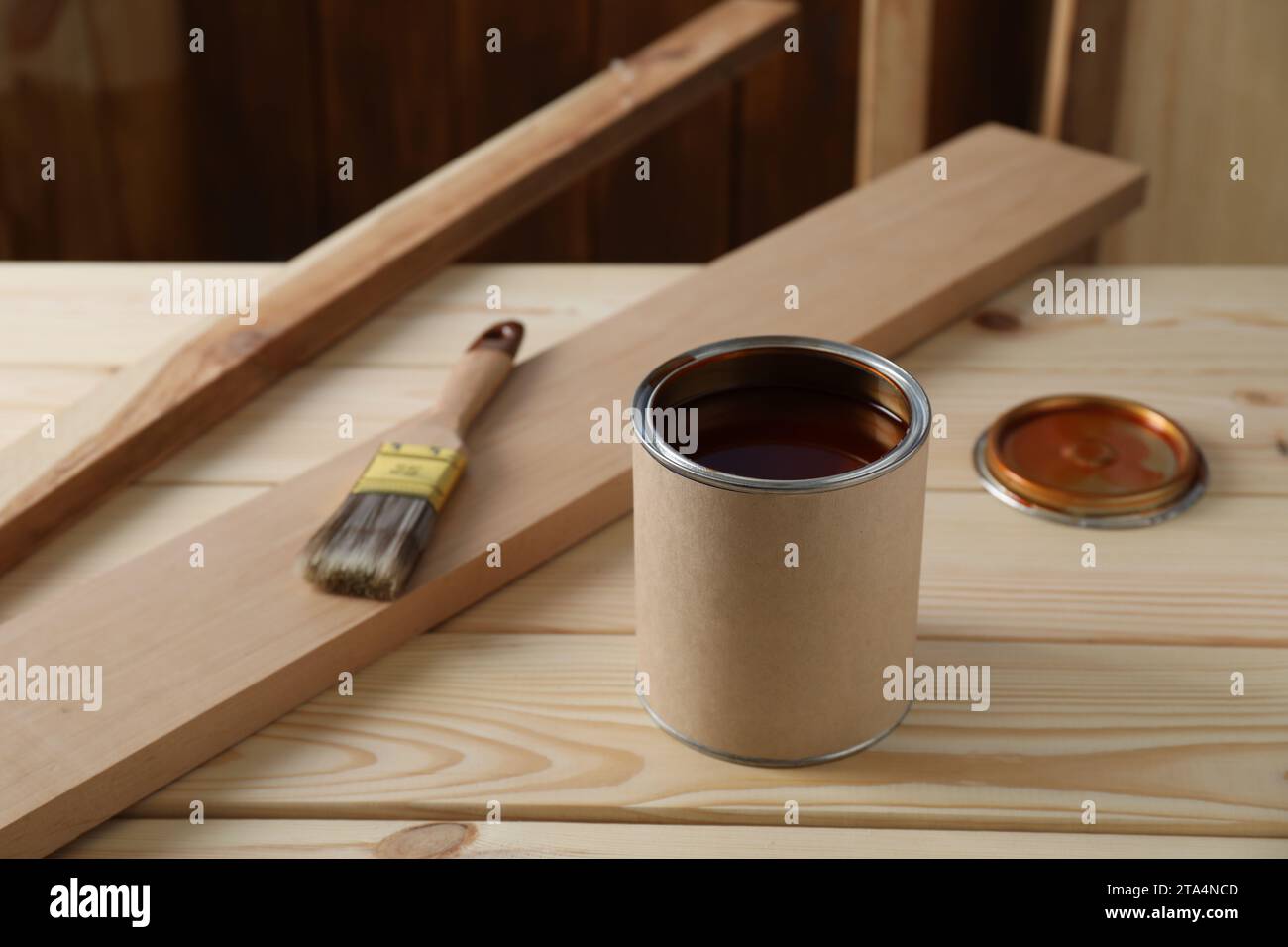 Can with wood stain on wooden surface Stock Photo - Alamy