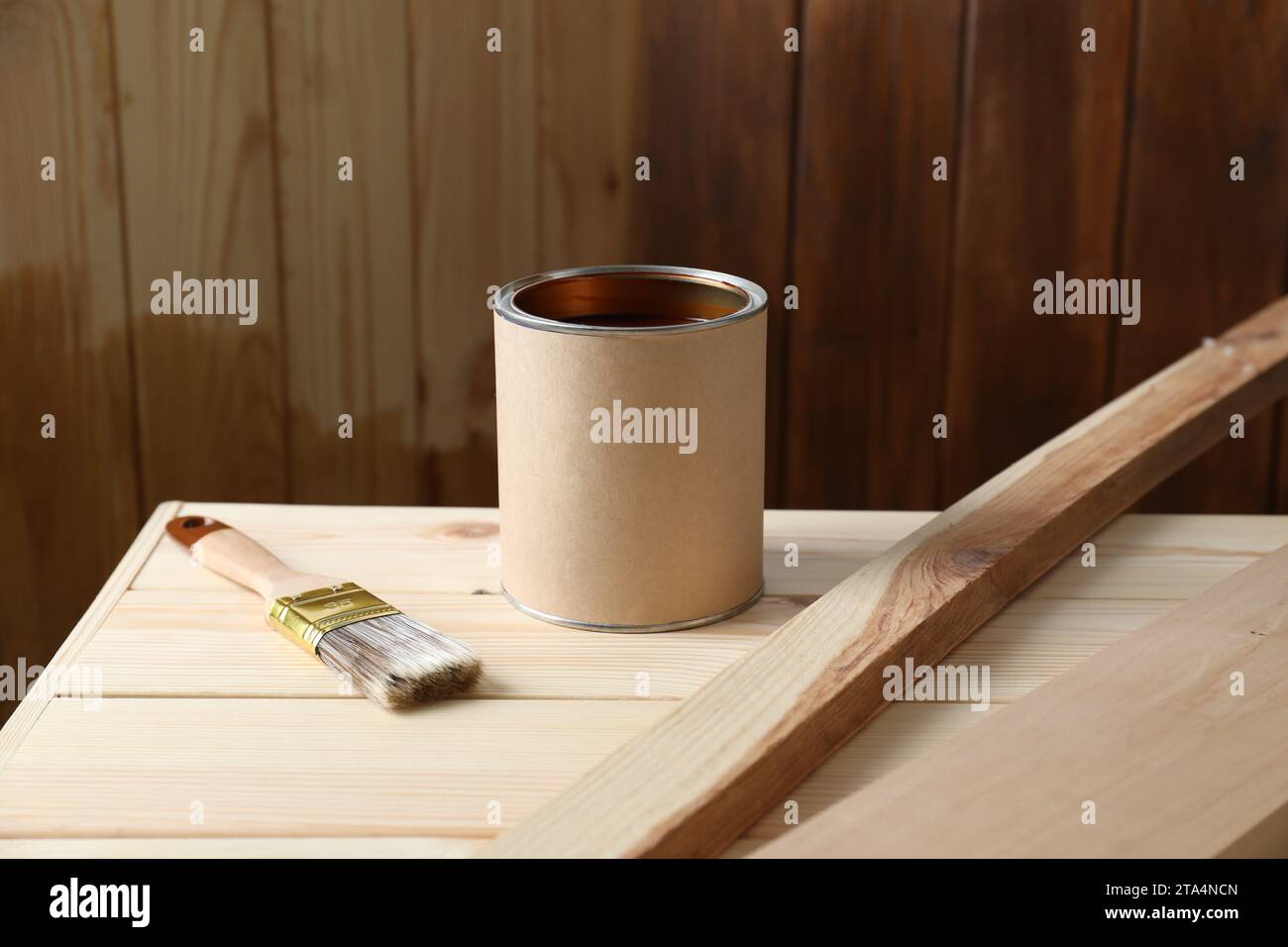 Can and brush with wood stain on wooden surface Stock Photo - Alamy