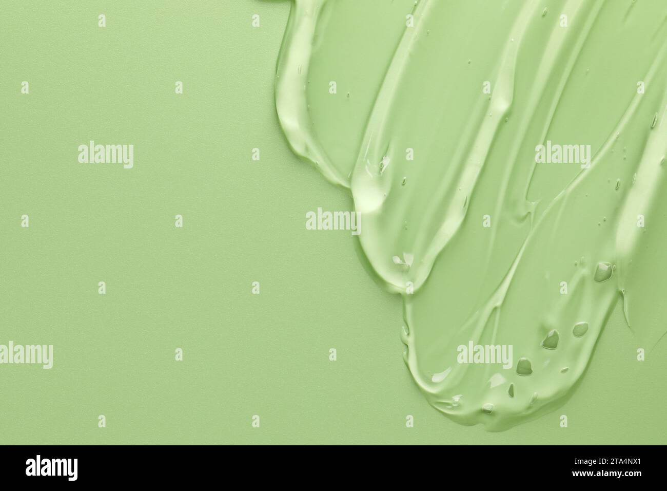 Clear cosmetic gel on light green background, top view. Space for text ...