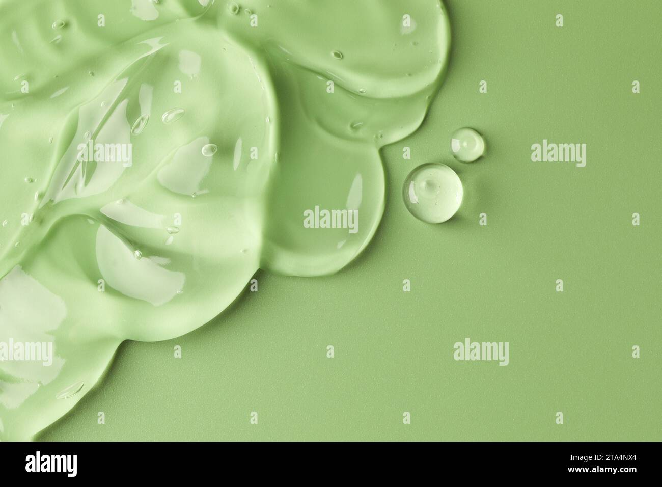 Clear cosmetic gel on light green background, top view. Space for text ...