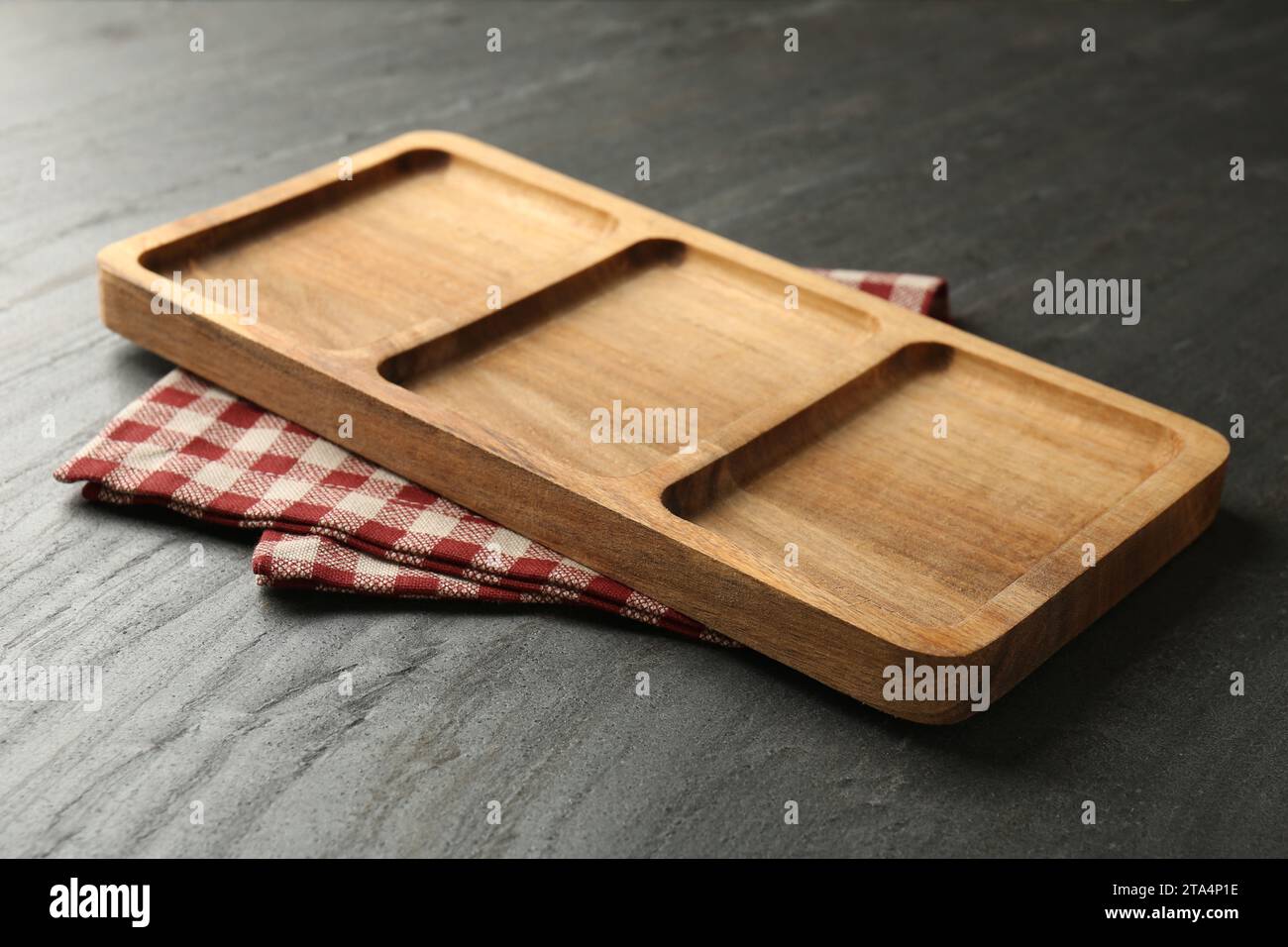 New wooden compartment tray and kitchen towel on dark grey table Stock ...