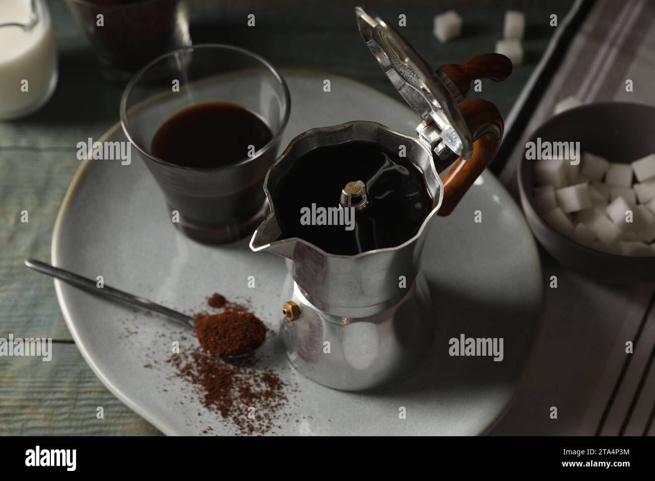 Brewed coffee in moka pot and glass on rustic wooden table, closeup ...