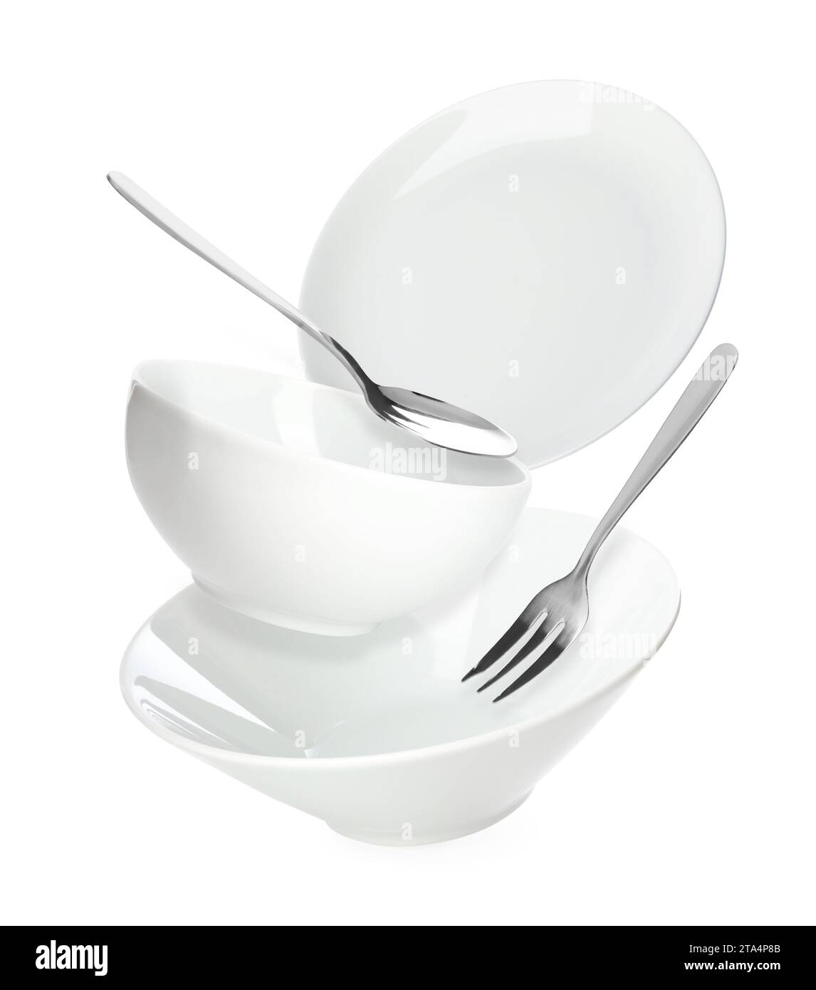 Clean dishes, spoon and fork falling on white background Stock Photo ...