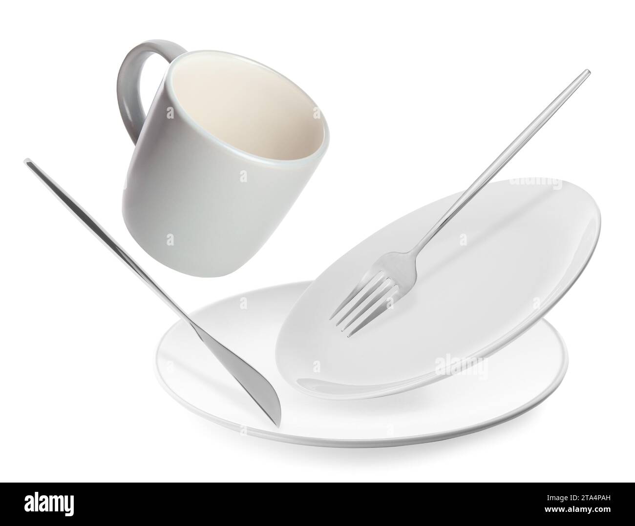 Clean plates, fork, knife and cup falling on white background Stock ...