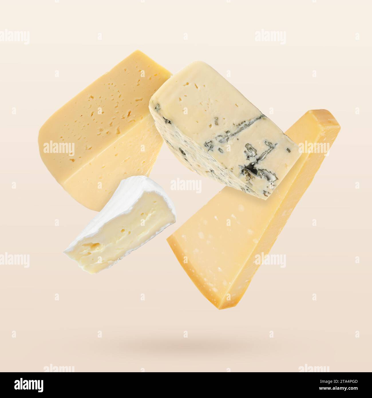 Different kinds of cheese falling on beige background Stock Photo - Alamy