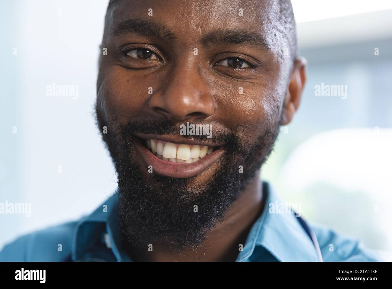 Portrait of happy african american male doctor wearing blue shirt in ...