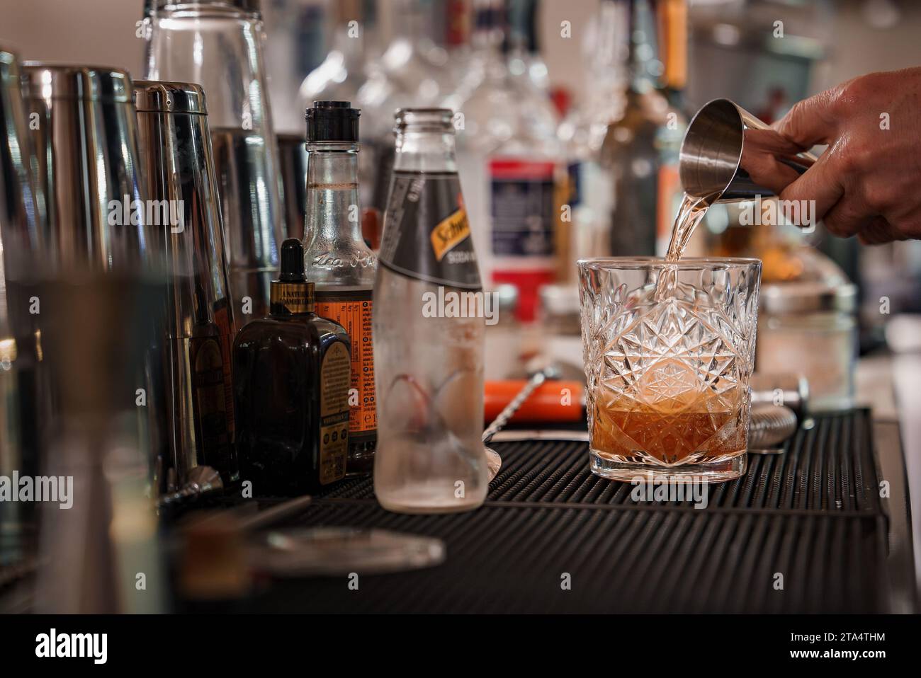 Bartender pouring drink into martini glass in luxury Venetian bar ...