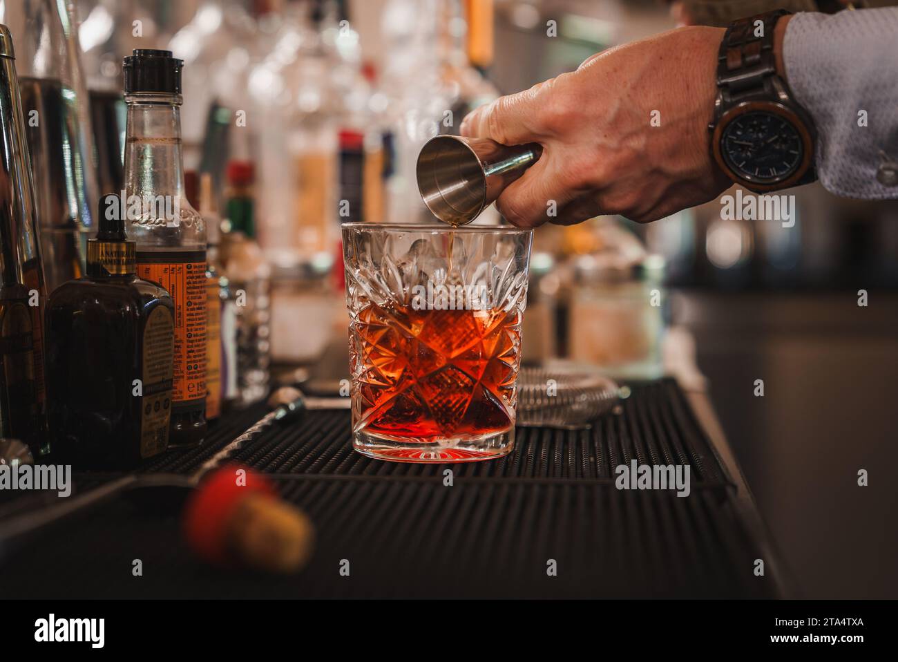 Bartender pouring a classic martini cocktail into a glass at a stylish bar counter Stock Photo ...