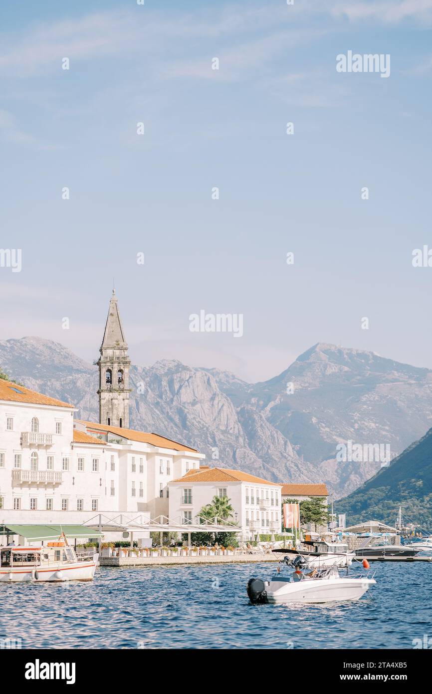 Yacht is moored off the coast of Perast overlooking ancient houses and ...