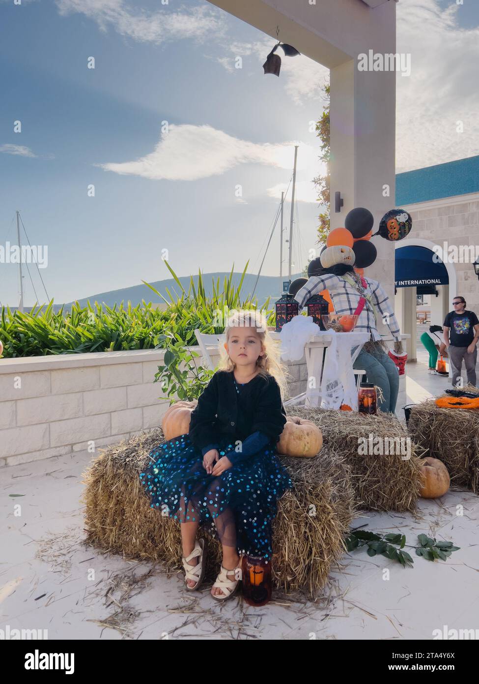 Little girl sits thoughtfully on a haystack near the scenery for ...