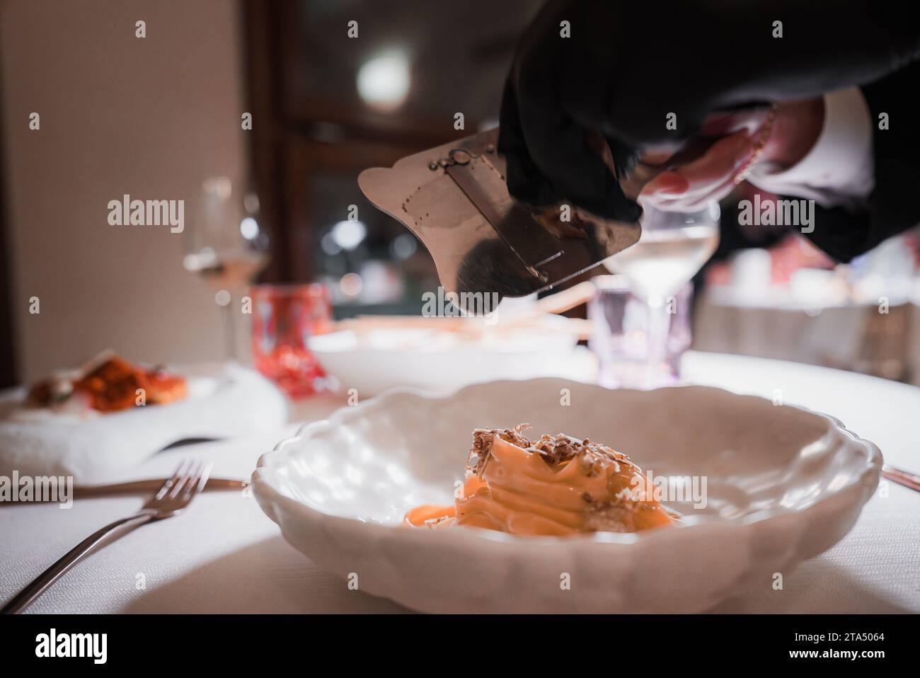 Elegant dining experience in Venice: Person using spoon to serve pasta ...