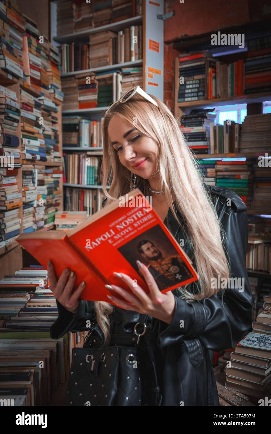 Serene woman engrossed in book in cozy traditional library in Venice ...