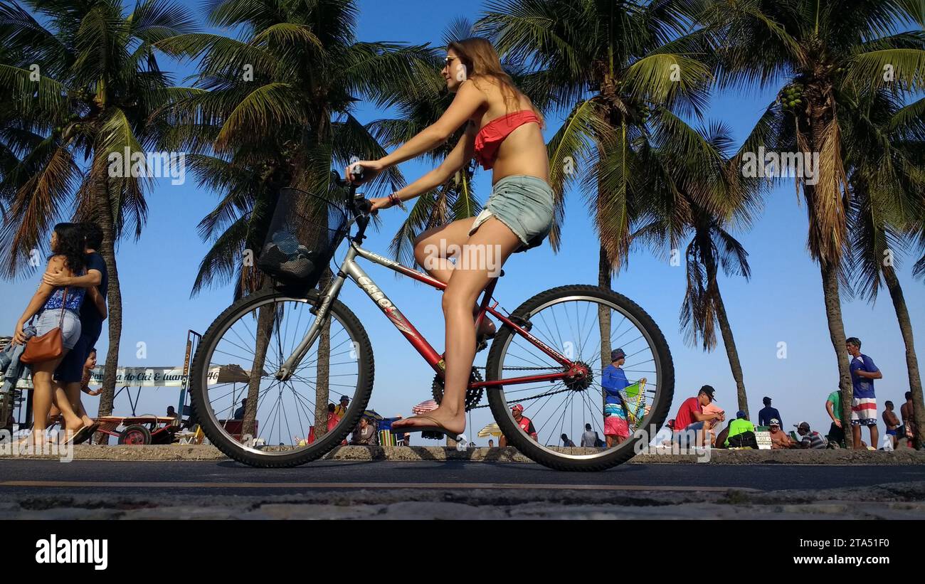 Cyclist rides on the bike lane located next to the Copacabana beach promenade, Rio de Janeiro ...