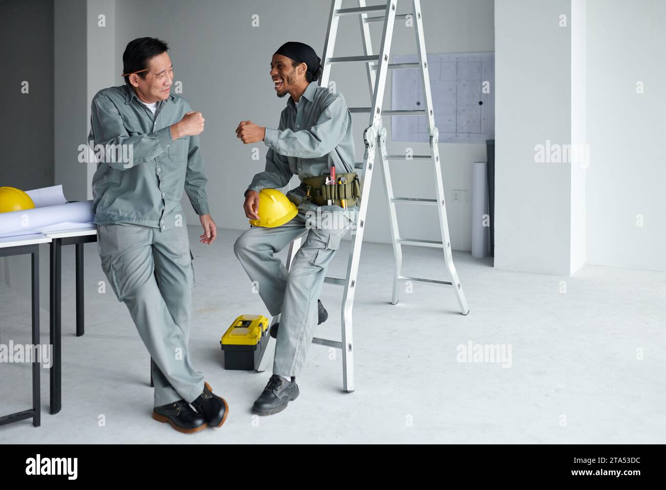 Construction worker giving each other fist bump after finishing shift at work Stock Photo - Alamy