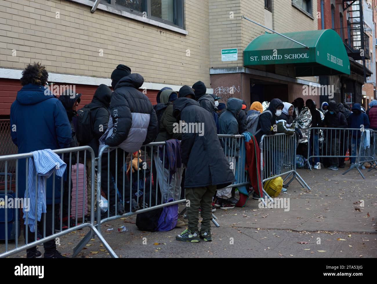 New York, New York, USA. 28th Nov, 2023. Migrants wait outside in the ...