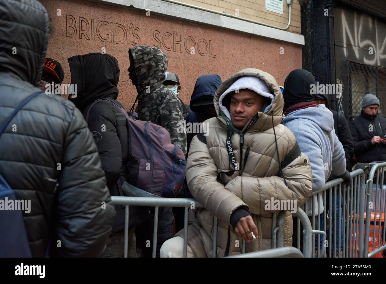 New York, New York, USA. 28th Nov, 2023. Migrants wait outside in the ...