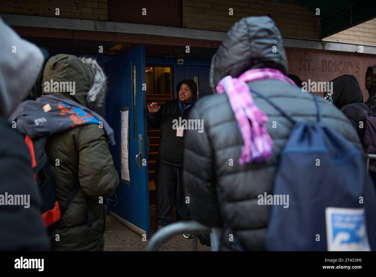New York, New York, USA. 28th Nov, 2023. Migrants wait outside in the ...