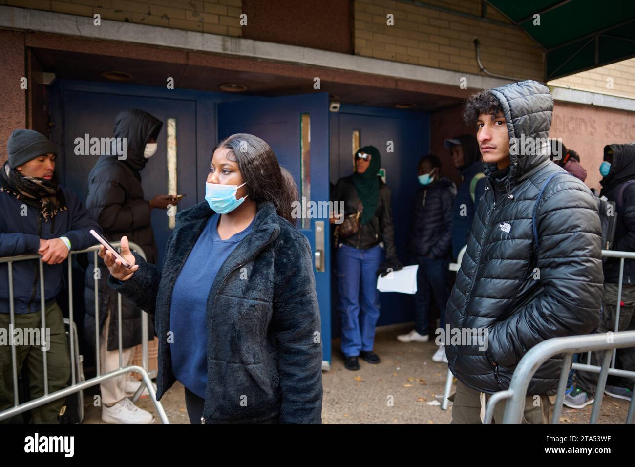 New York, New York, USA. 28th Nov, 2023. Migrants wait outside in the ...
