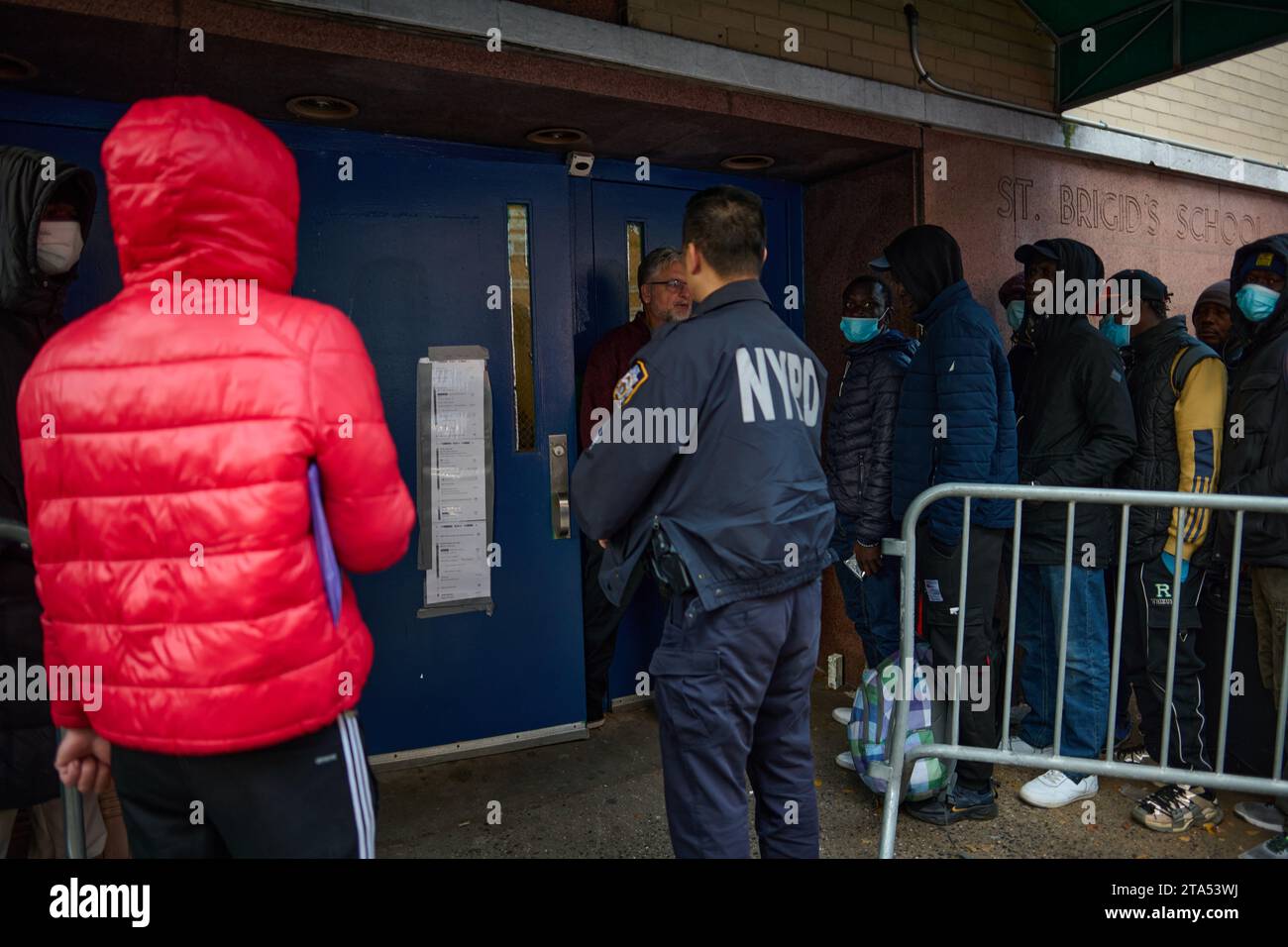 New York, New York, USA. 28th Nov, 2023. Migrants wait outside in the ...