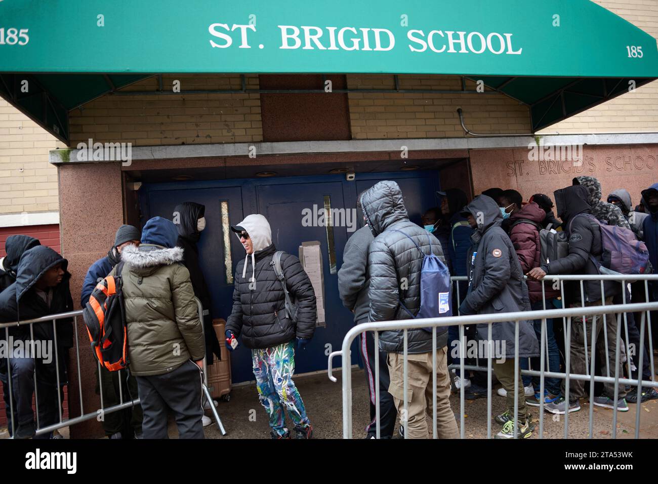 New York, New York, USA. 28th Nov, 2023. Migrants wait outside in the ...