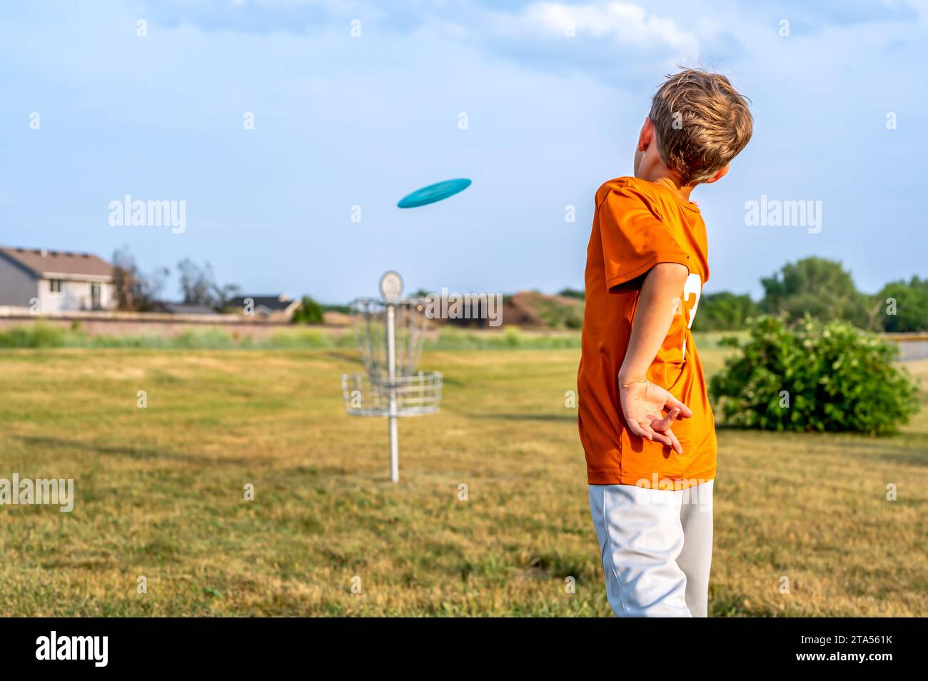 Young Caucasian male boy aiming a disc golf at a chain goal Stock Photo ...