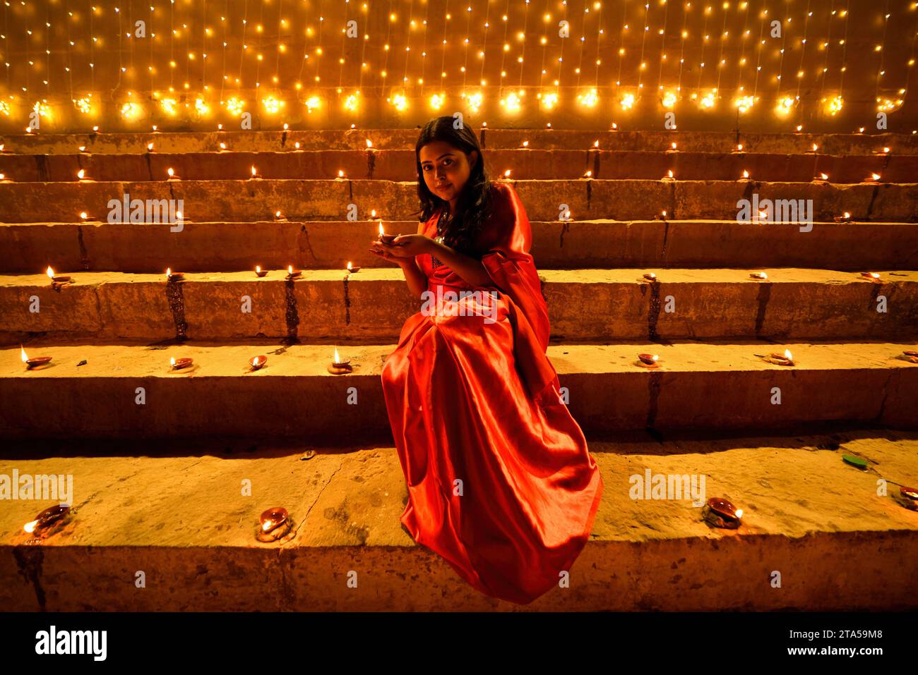 Varanasi, India. 27th Nov, 2023. A lady poses for a photo while holding ...
