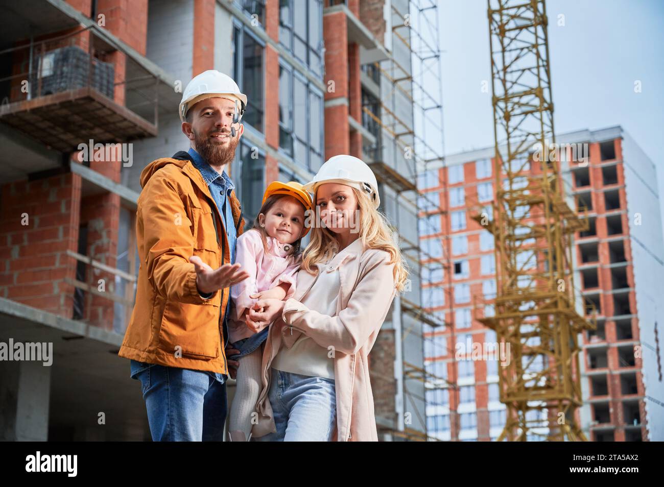 Man tossing up apartment keys and smiling while standing next to wife ...