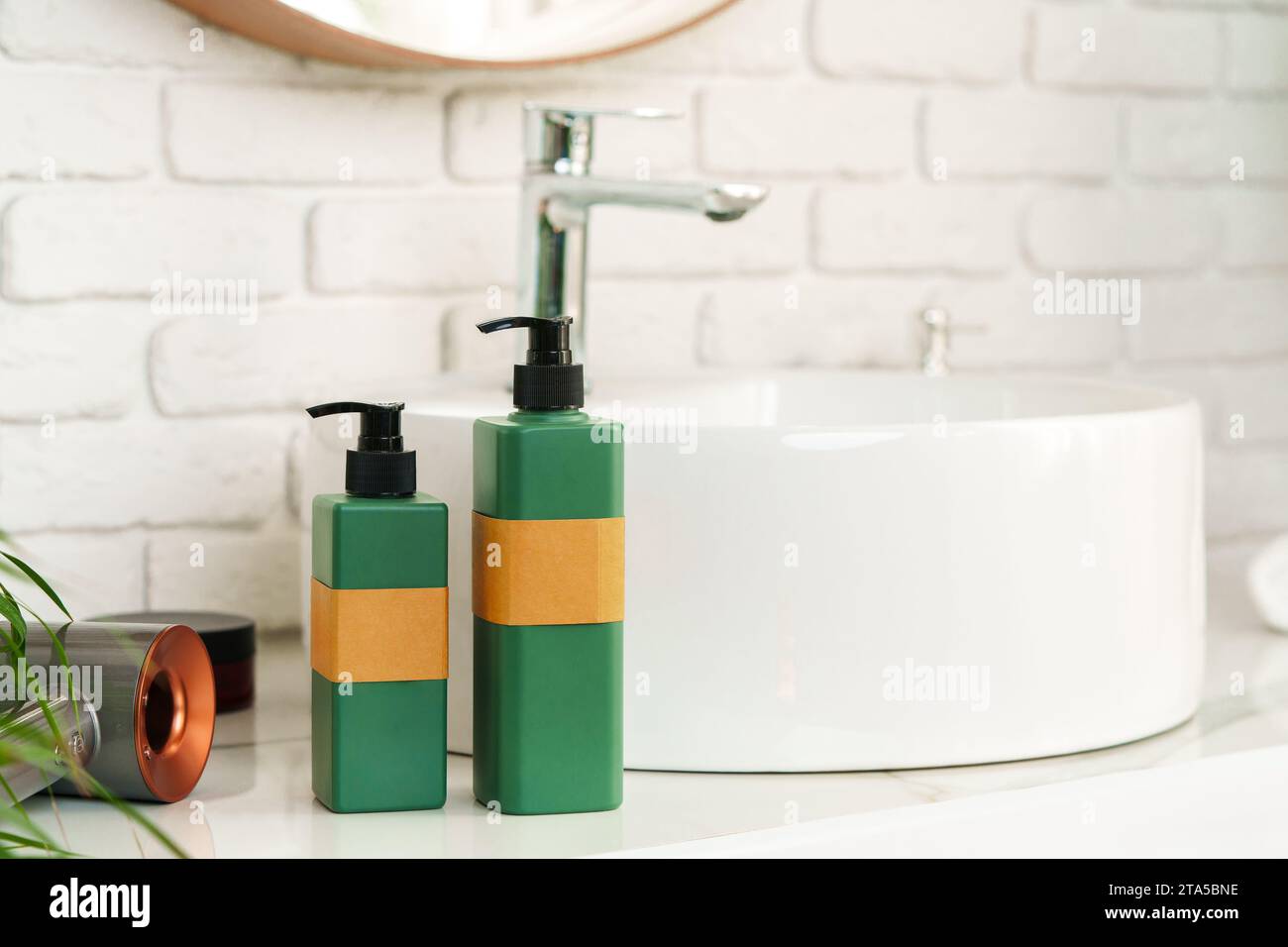 Soap and cream dispenser jars near the sink in a bathroom Stock Photo ...
