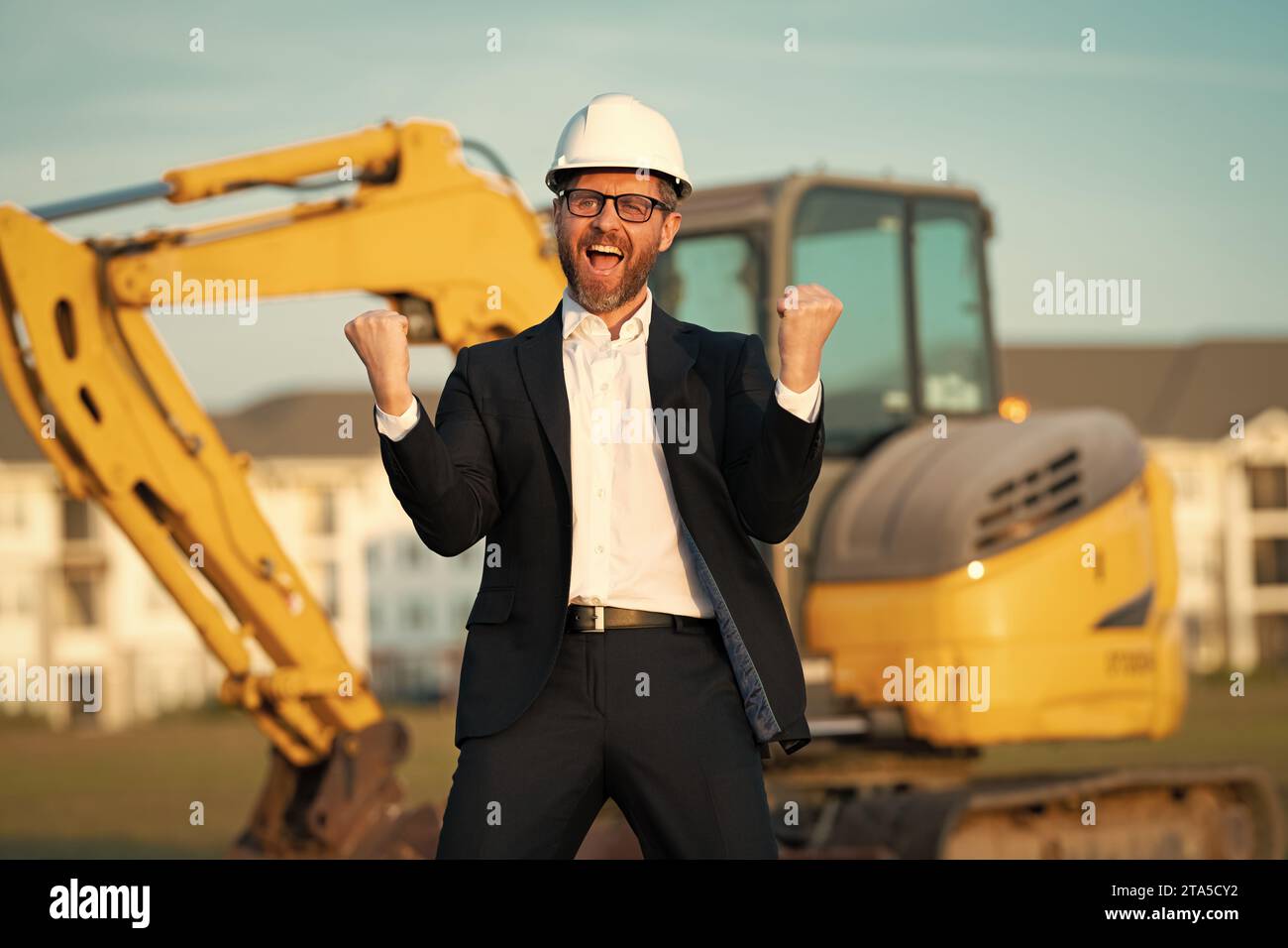 Architect at a construction site. Architect man in helmet and suit at ...