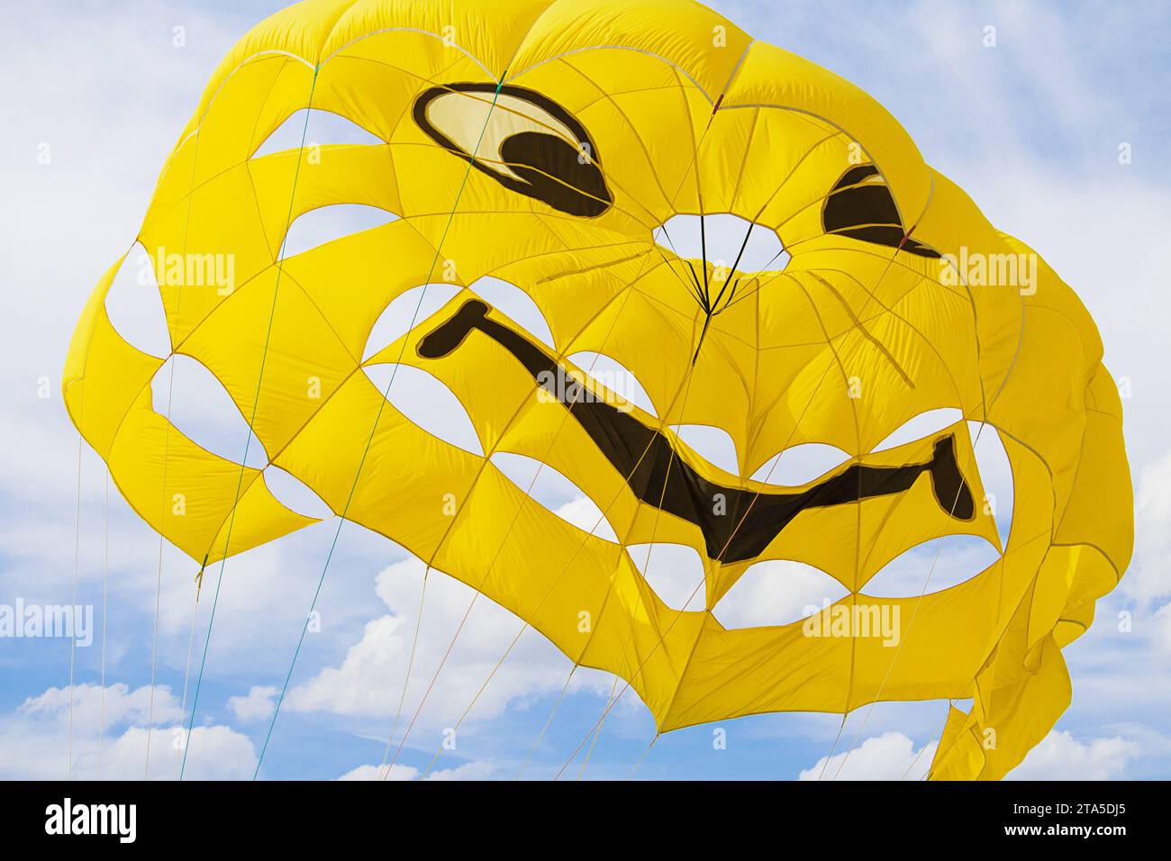 Bright yellow parachute with smile on sky with clouds background ...