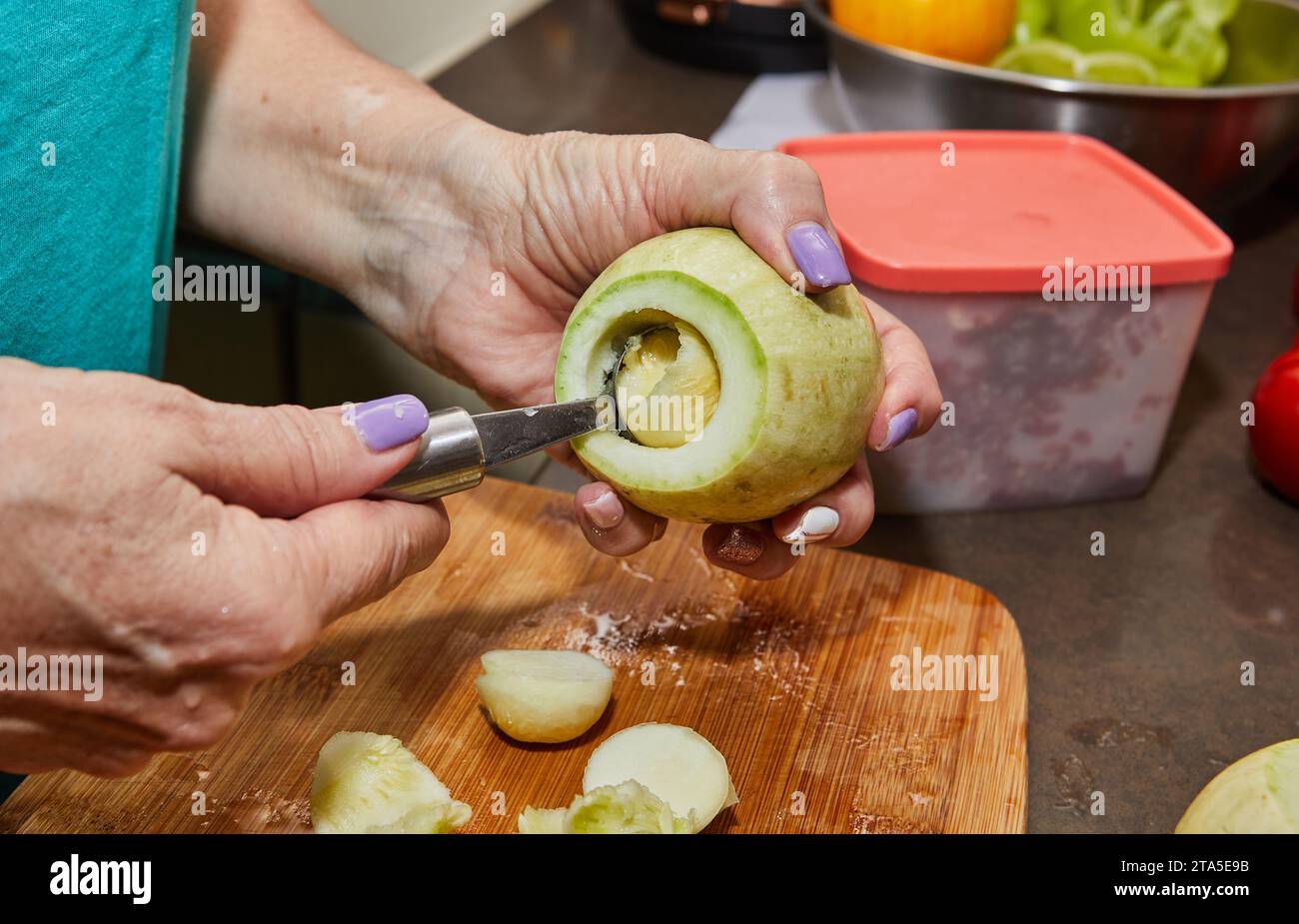 Chef cuts out the inside of zucchini for stuffing in home kitchen Stock ...