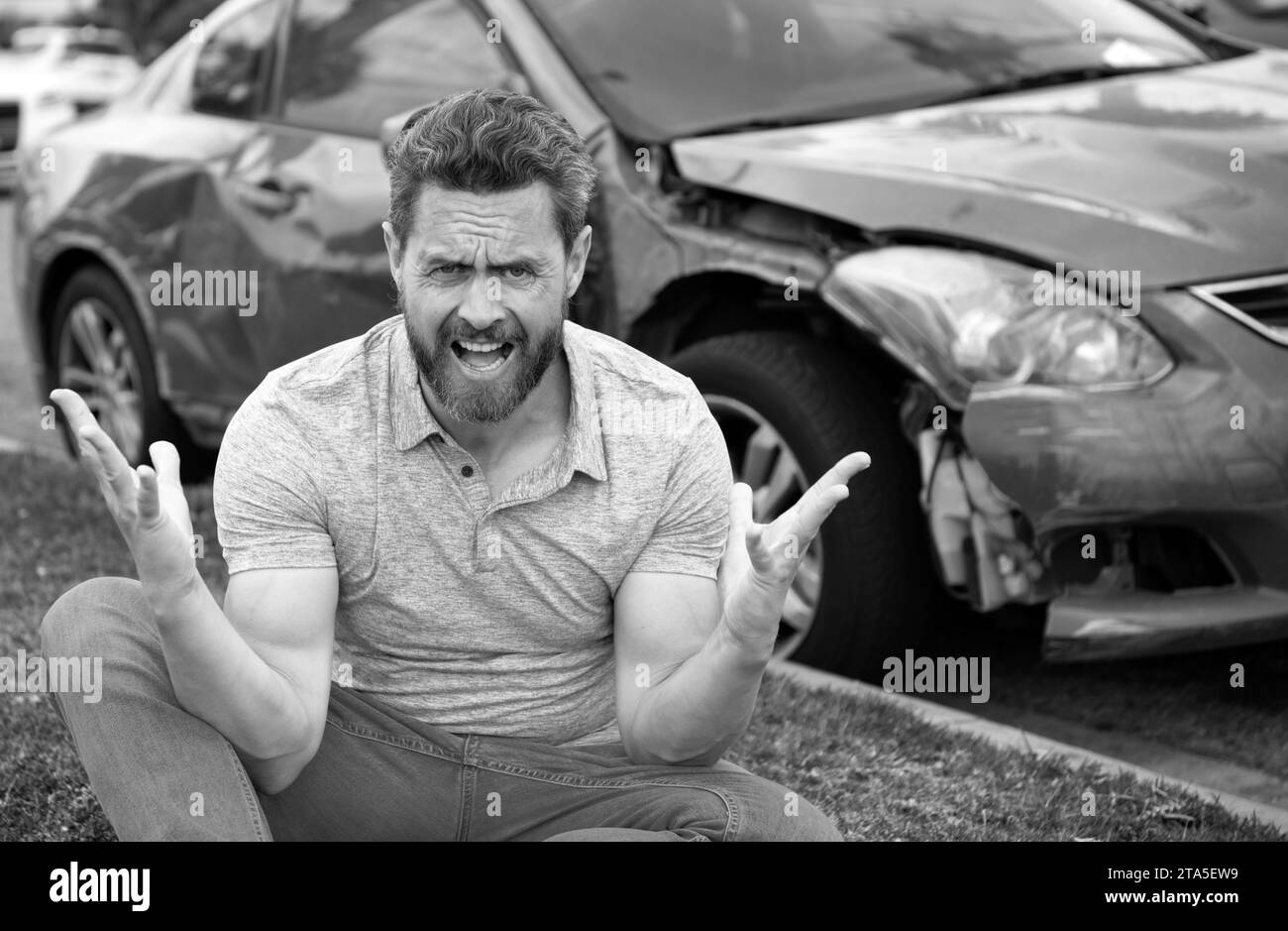 Stressed driver sitting on the road next to broken car Stock Photo - Alamy